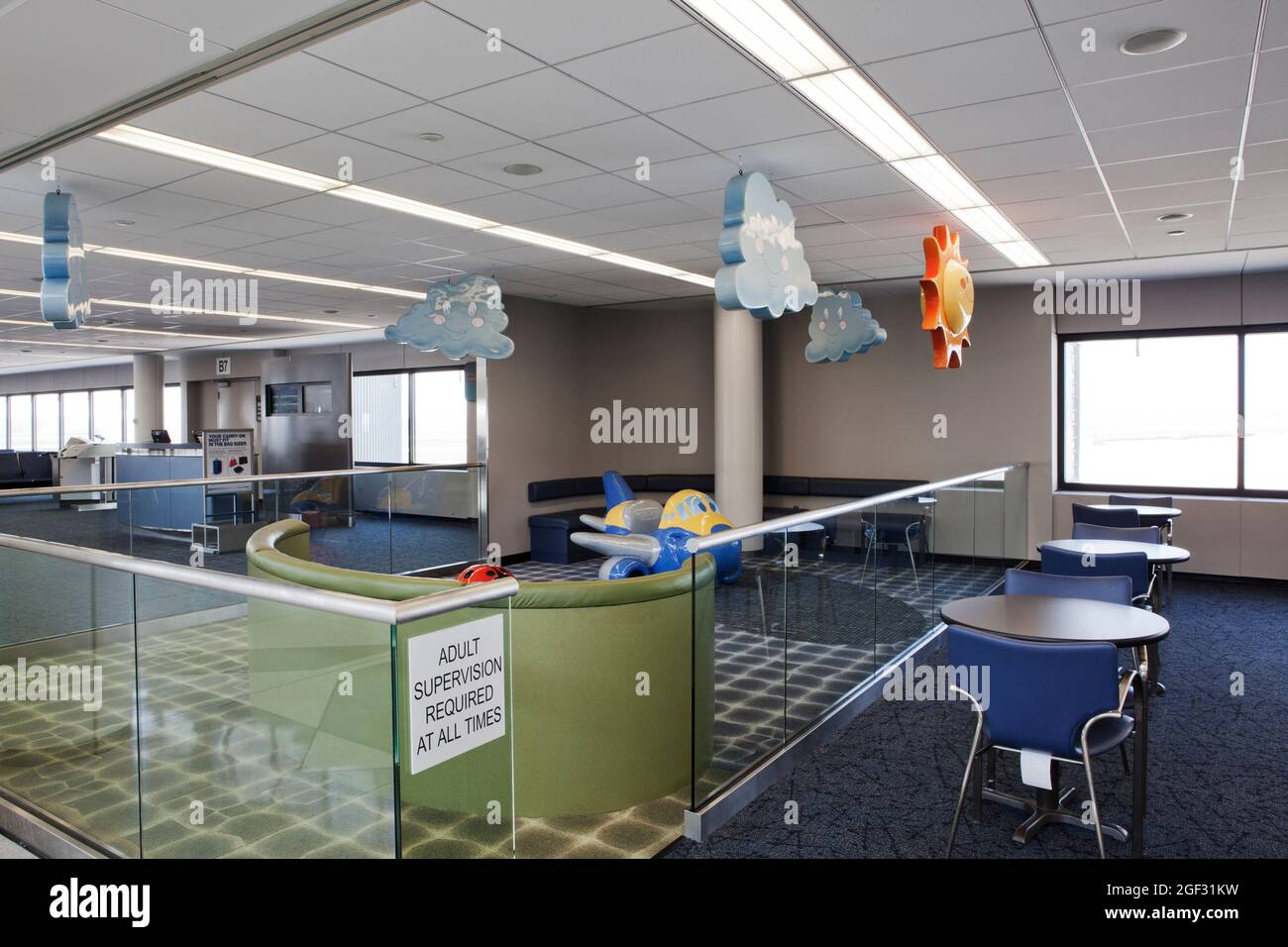 An airport departure lounge children's play area with signs. Tables and ...