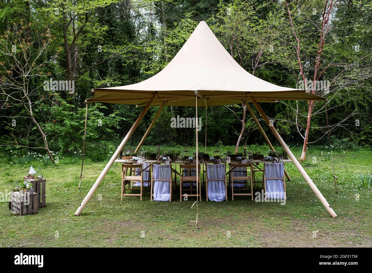Dining table and chairs under a canopy for a woodland naming ceremony ...