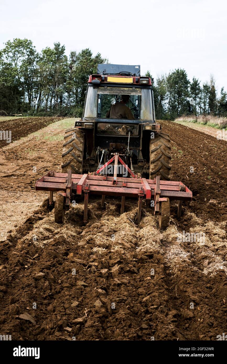 Rear view of tractor plowing a field on a farm Stock Photo - Alamy