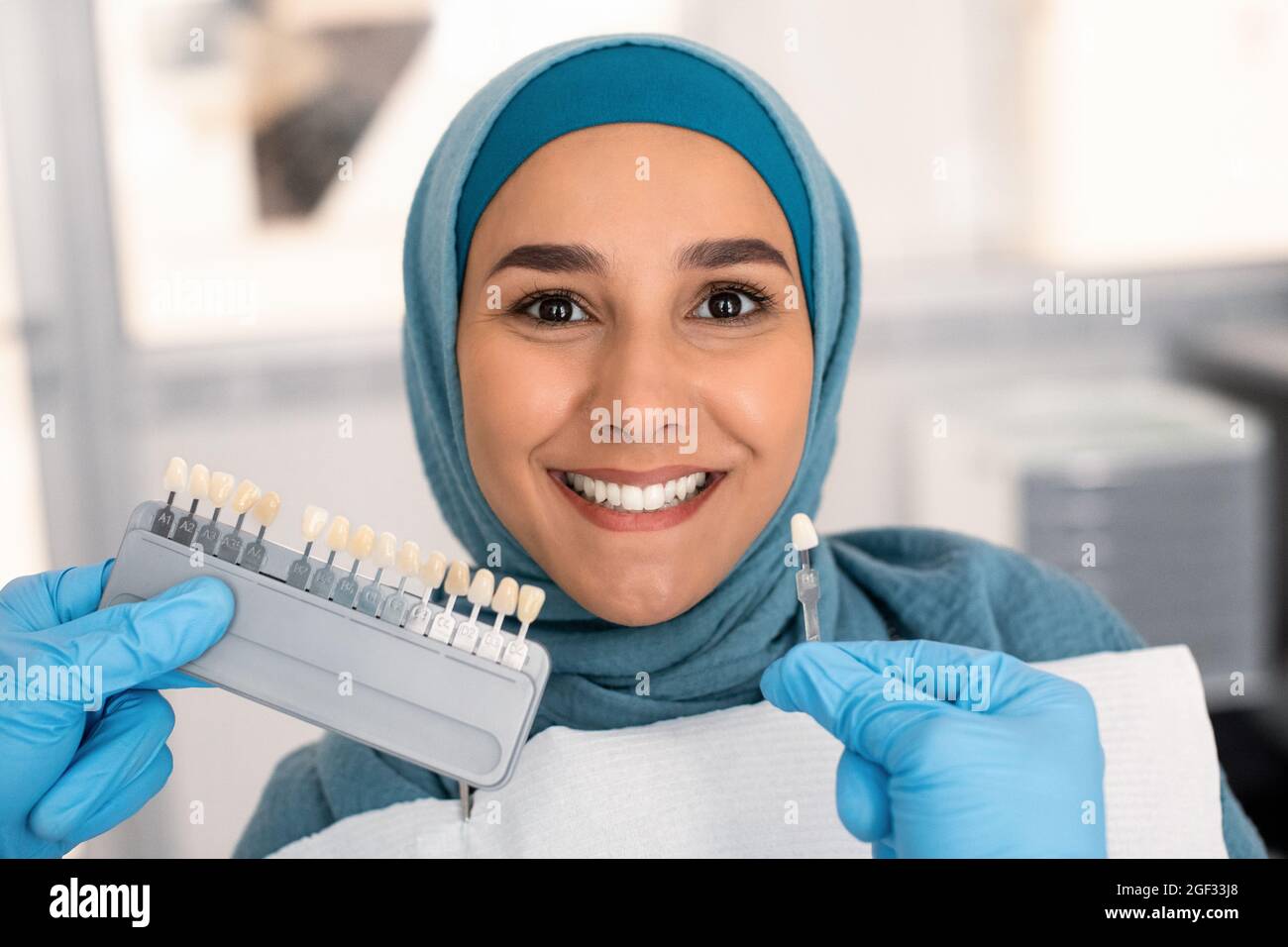 Dentist Doctor Choosing Right Emanel Color For Muslim Female Patient In ...