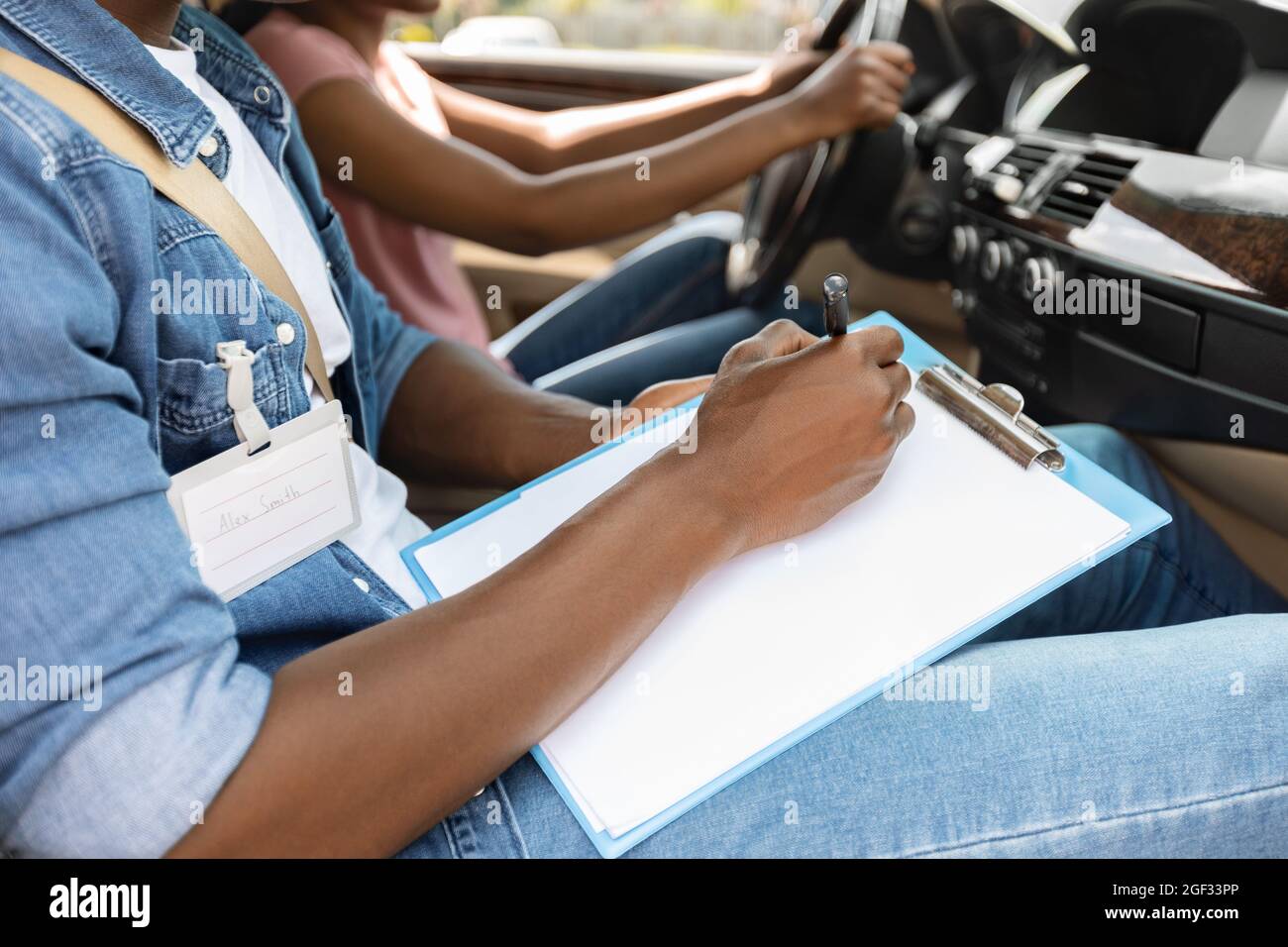 Driving instructor taking notes during exam, driving school concept ...