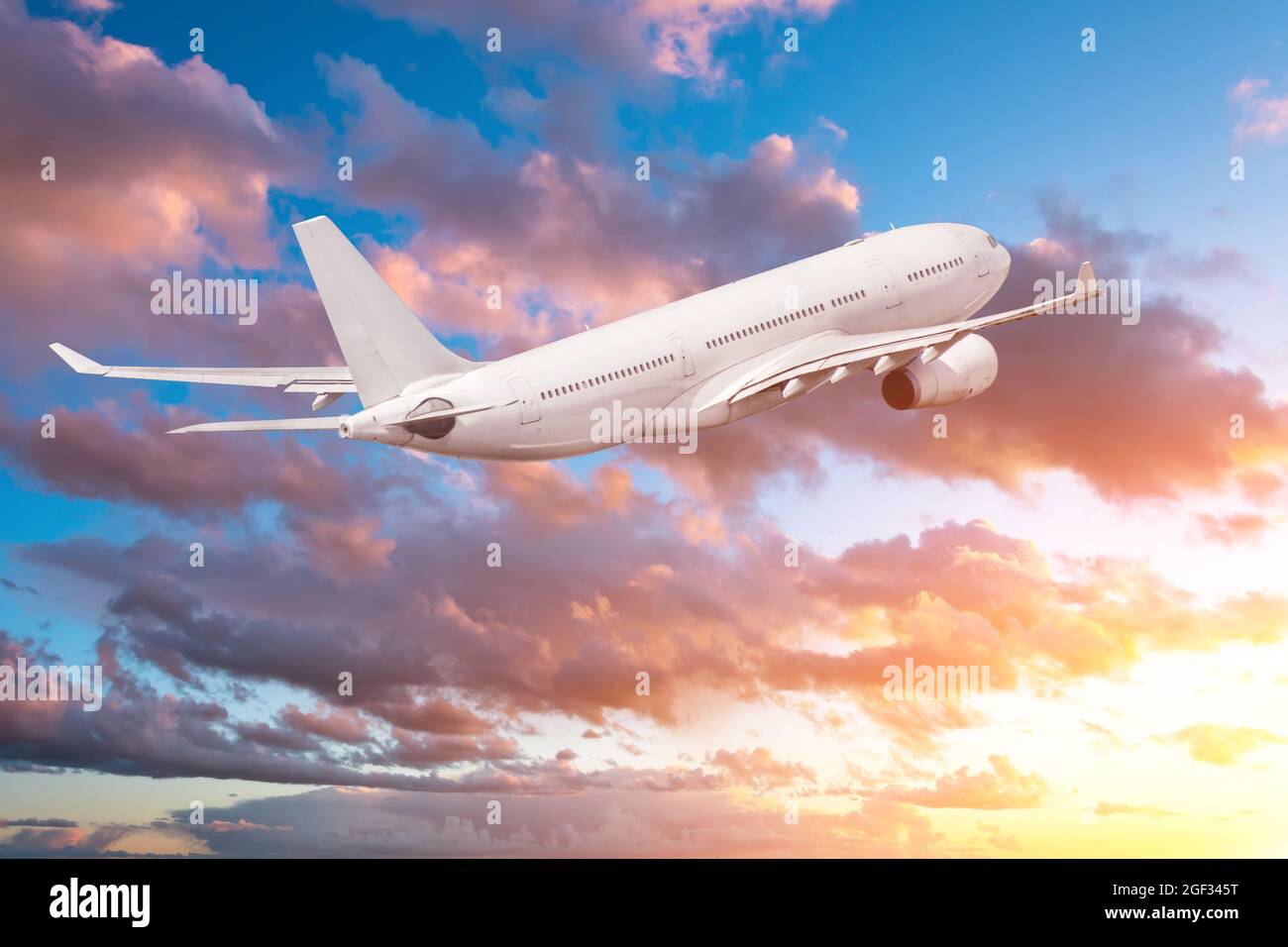 Airplane flying gaining height in the evening at sunset, the sky and ...