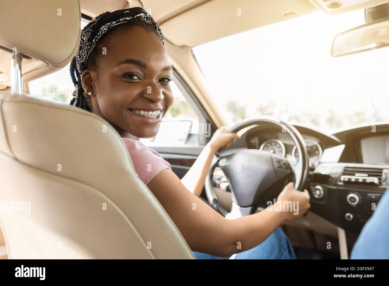 Confident black woman driving car, smiling at camera Stock Photo - Alamy