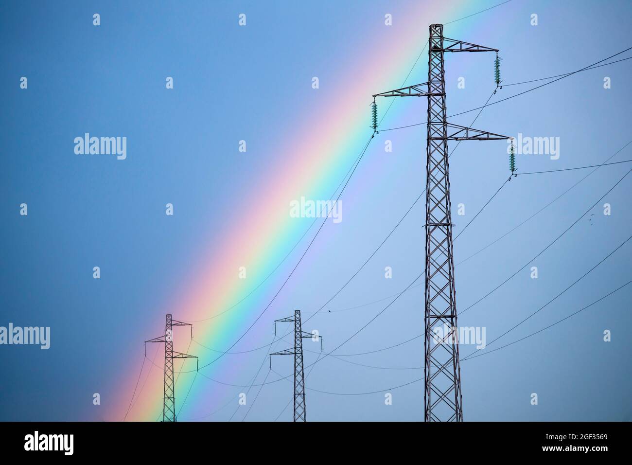 Effects arc of a rainbow near a high-voltage power line Stock Photo - Alamy