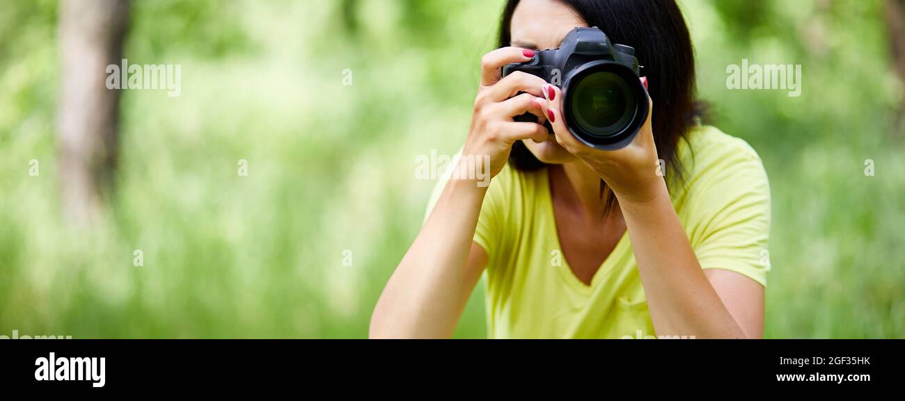 Banner of Portrait of a woman photographer covering her face with the ...
