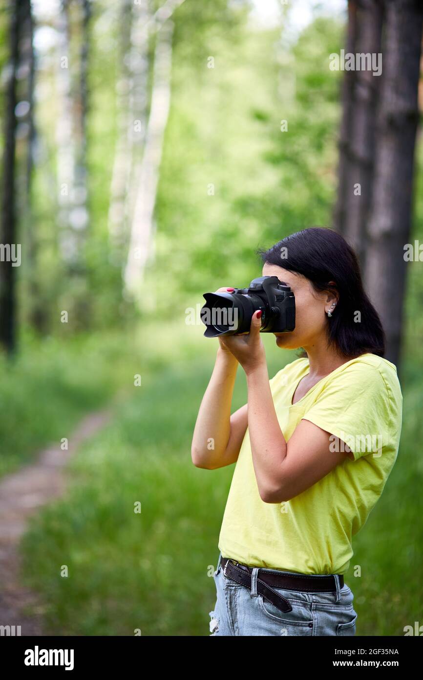 Portrait of a woman photographer covering her face with the camera ...