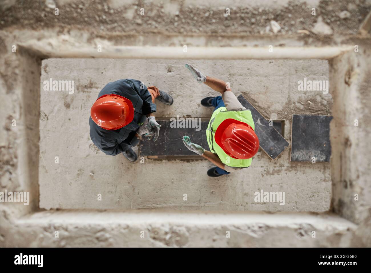 Top down view at two construction workers wearing hardhats at ...