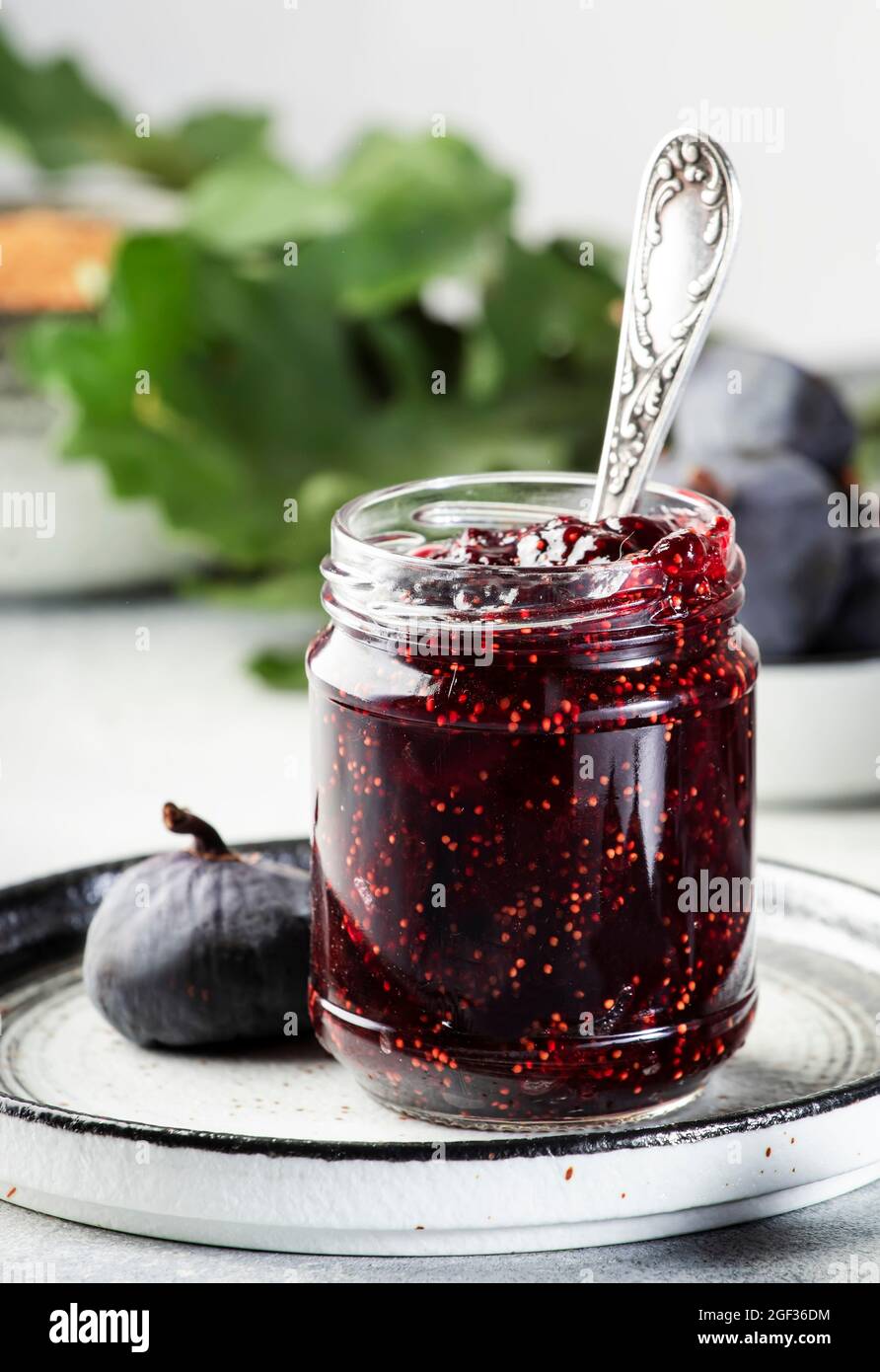Fig confiture in glass jar. Fresh fruits on gray kitchen table ...