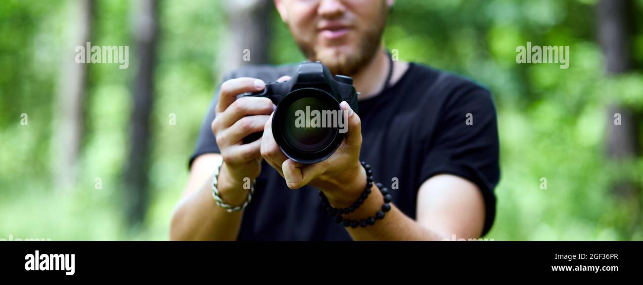 Banner of Portrait of a male photographer covering her face with the ...