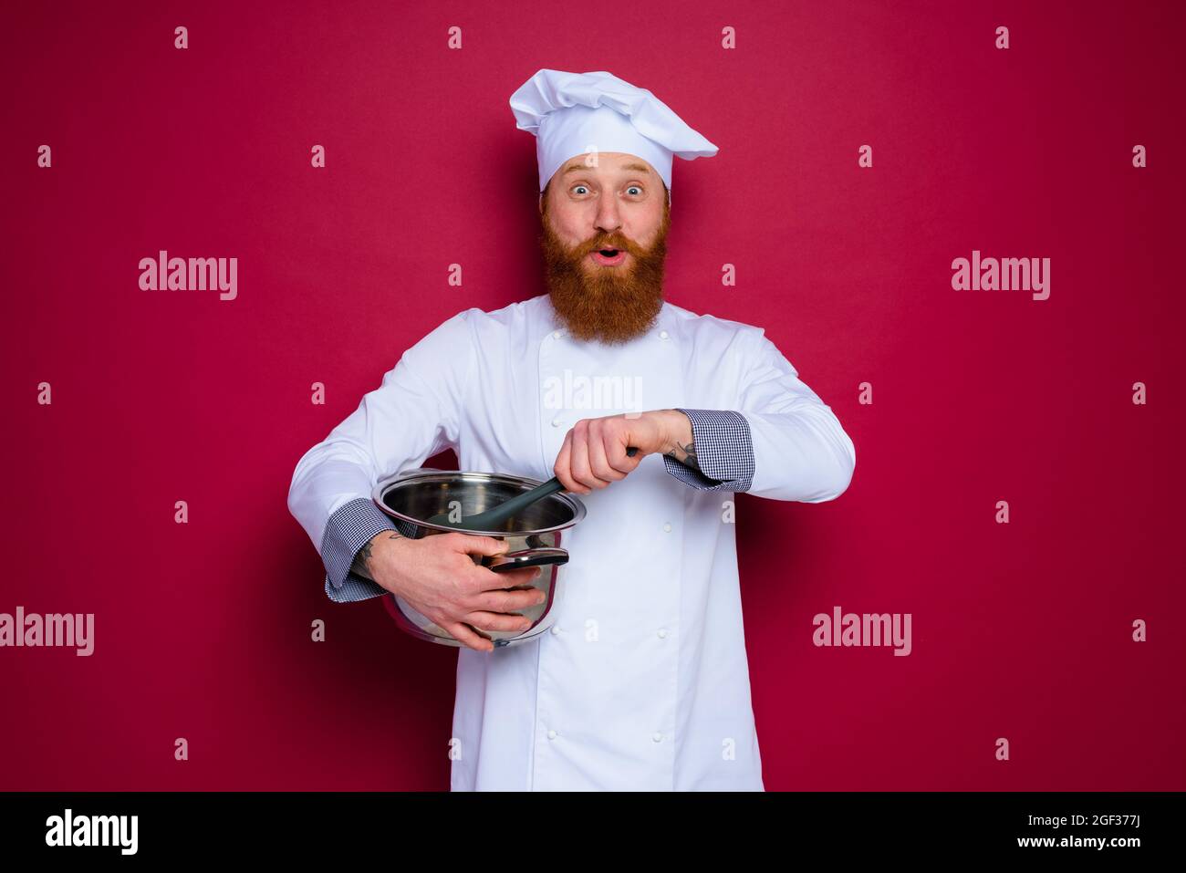 Happy chef with beard and red apron is ready to cook Stock Photo - Alamy