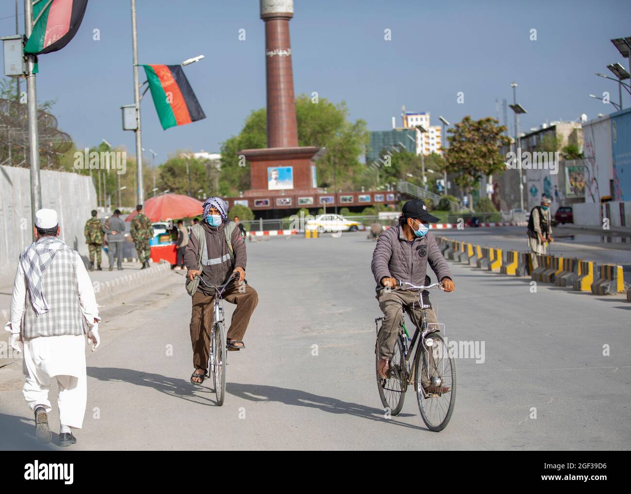 Afghan men ride their bikes while wearing face masks to protect ...