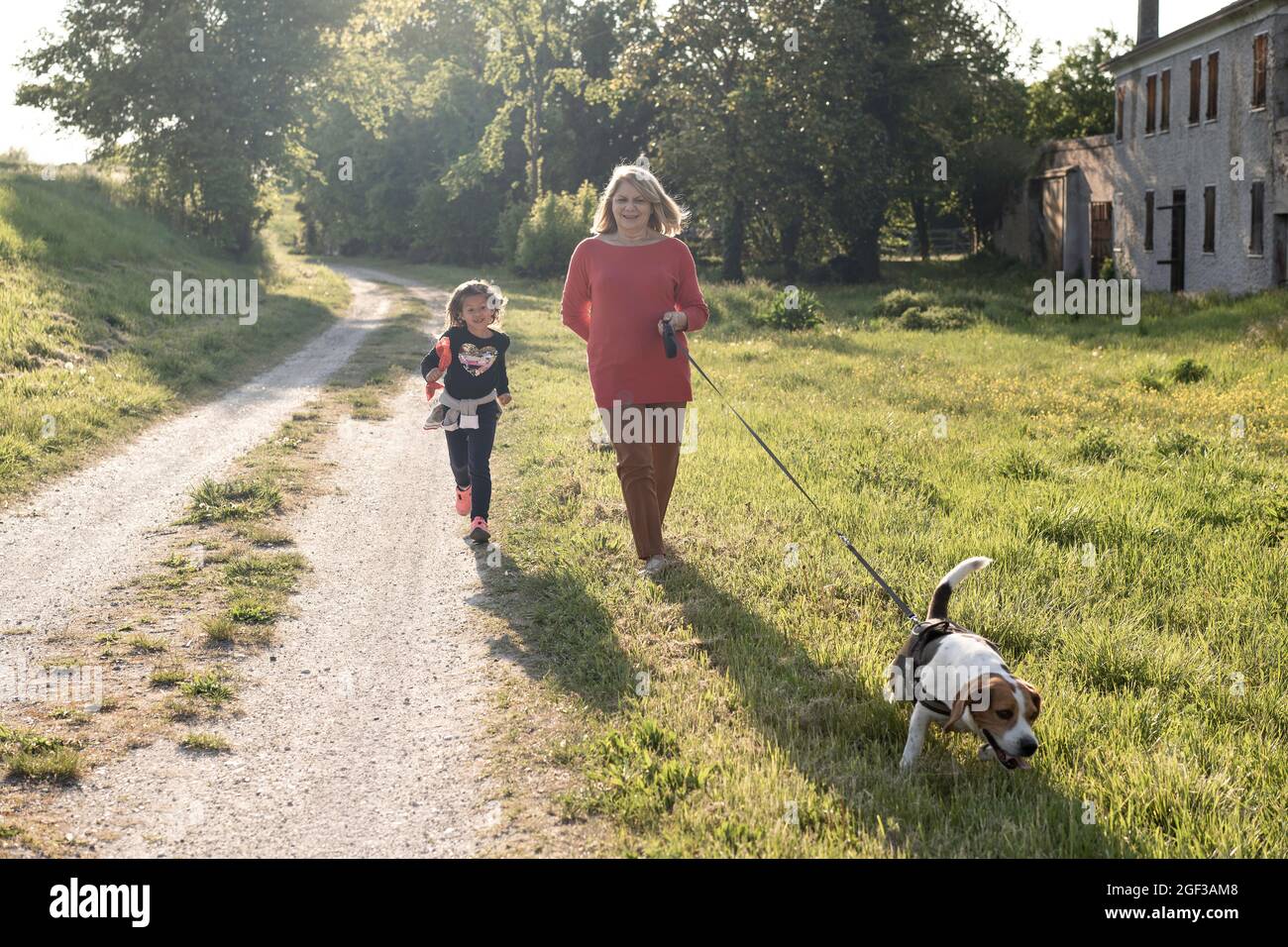 Trendy senior lady and her little toddler girl enjoying a walk in the ...