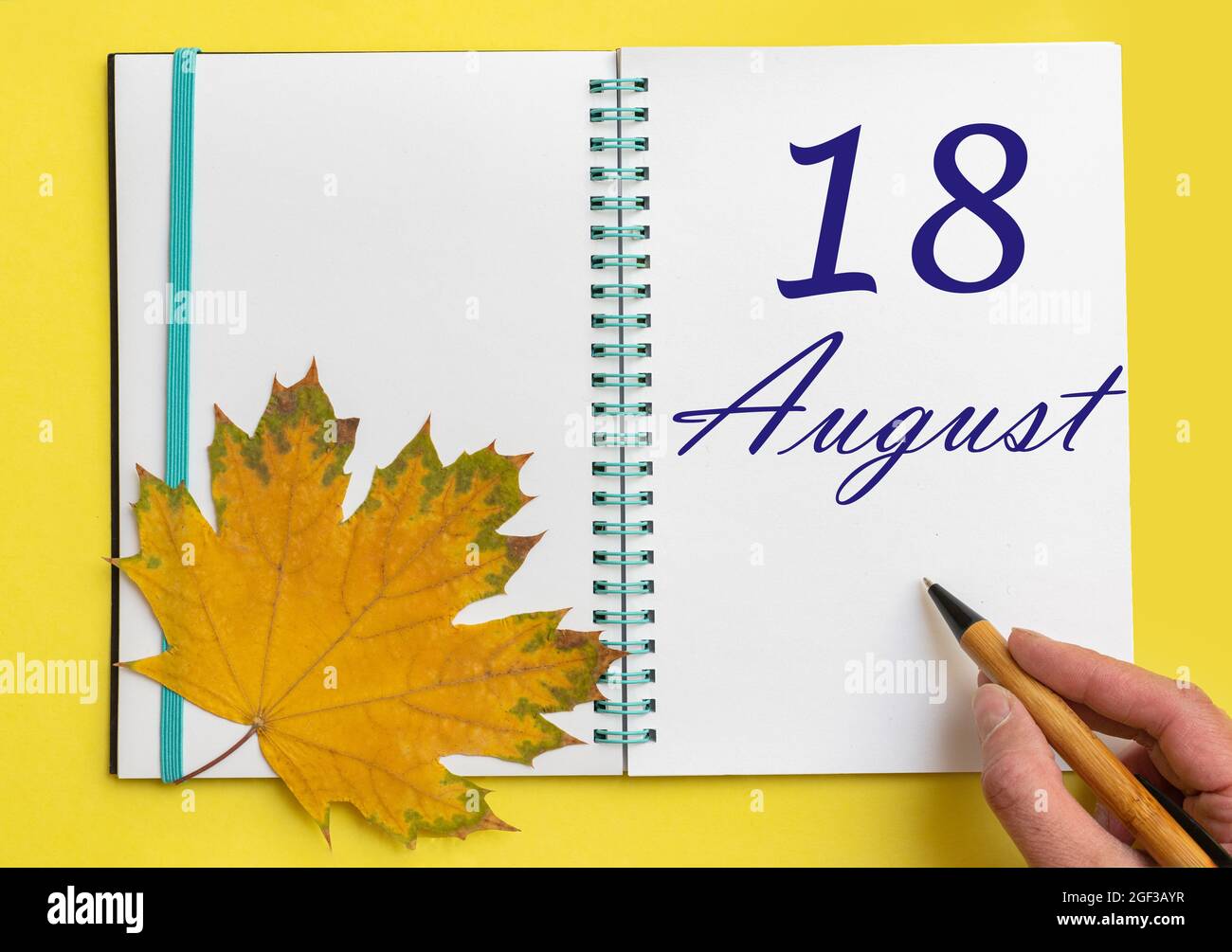 18th day of august. Hand writing the date 18 august in an open notebook ...