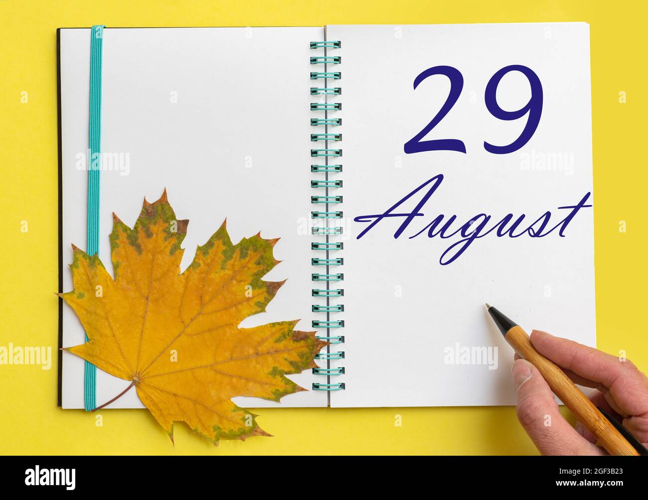 29th day of august. Hand writing the date 29 august in an open notebook ...