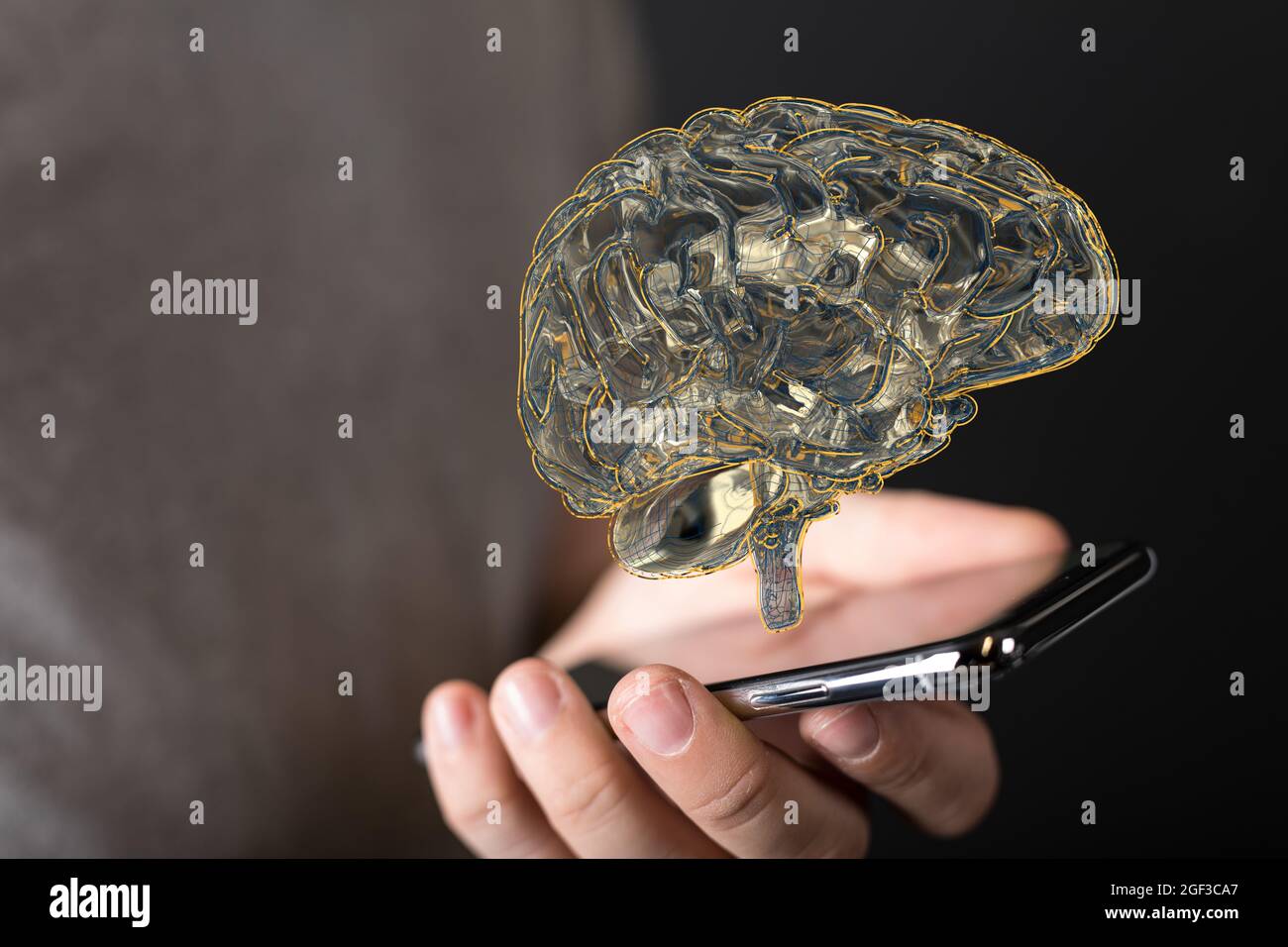 Male's hand holding his smartphone with a floating 3D human brain icon ...