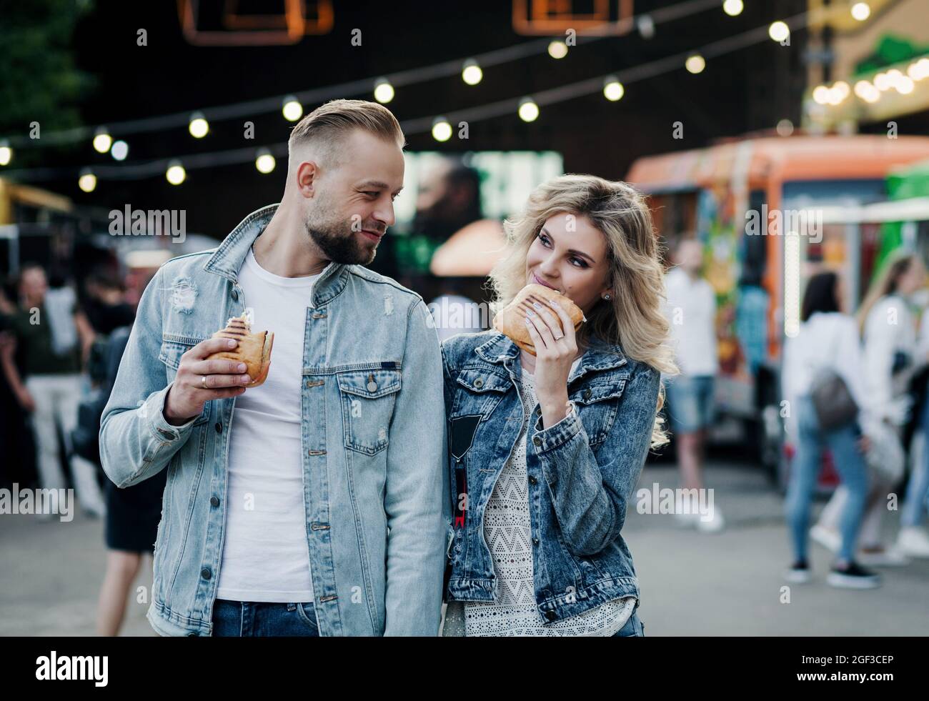 Young couple eating burger outdoors hi-res stock photography and images ...