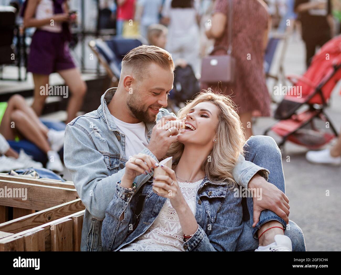 happy attractive young couple is romantically eating cheese balls ...
