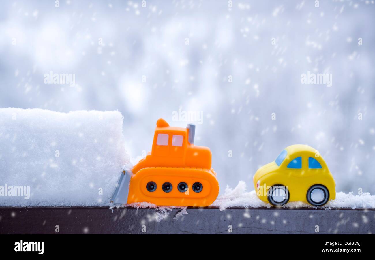 Toy snow plow in winter landscape. Road safety concept, street cleaning ...