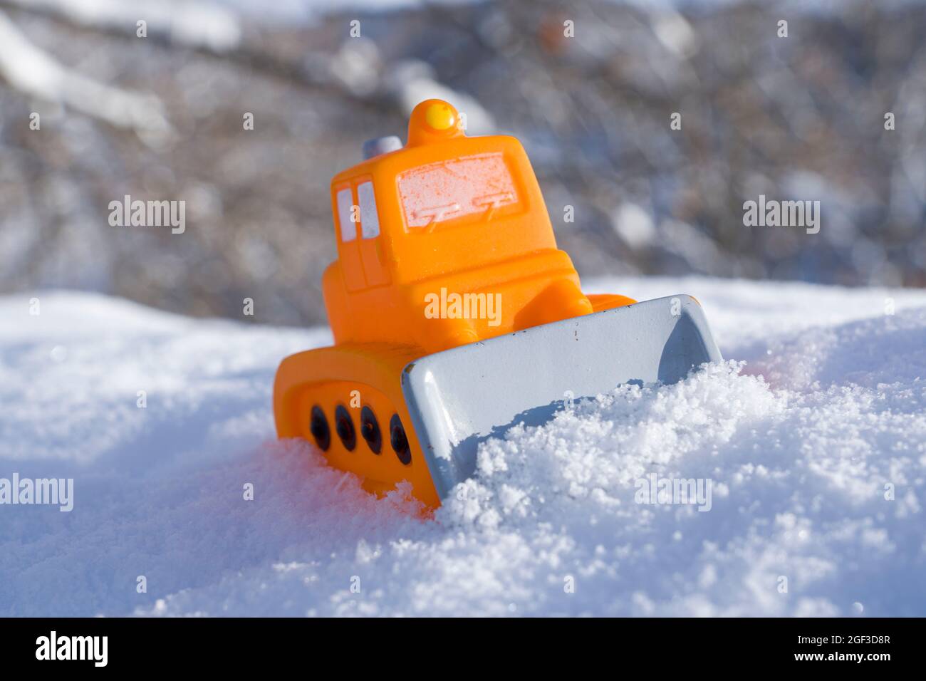 Toy snow plow in winter landscape. Road safety concept, street cleaning ...