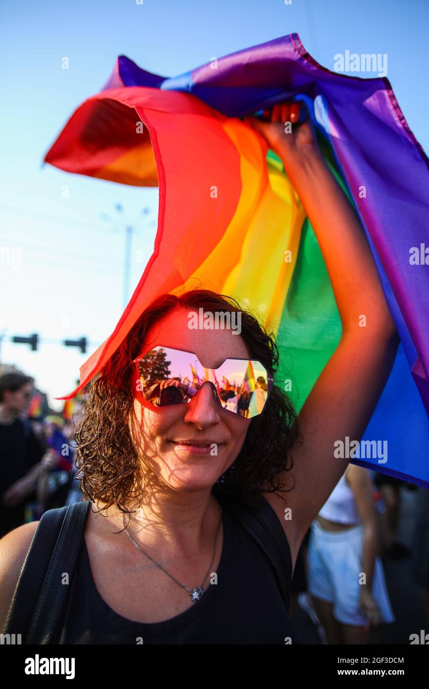 A participant is seen wearing a sunglasses and holding a rainbow flag ...