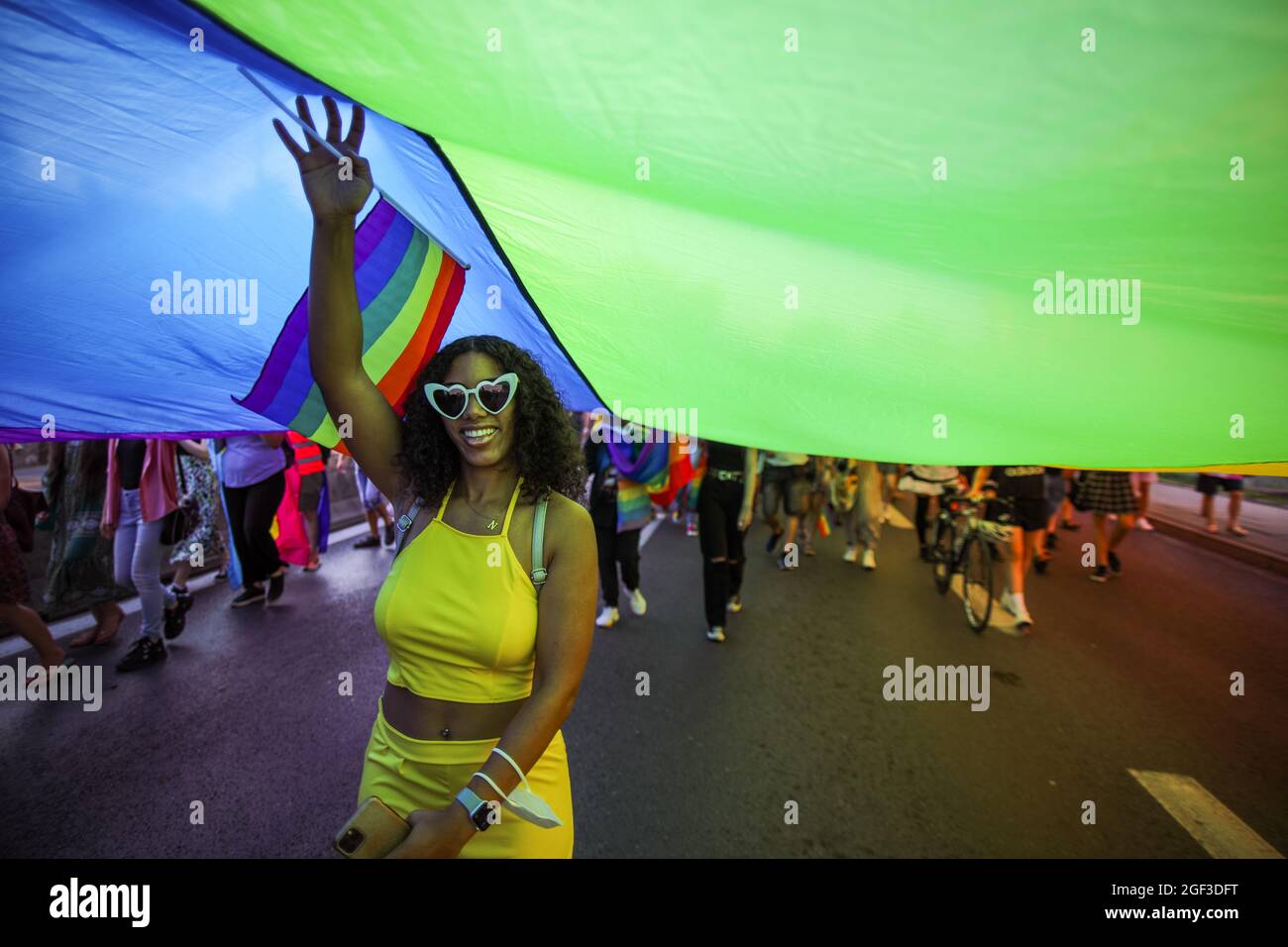 Member of LGBTQ community is seen walking under a giant rainbow flag ...