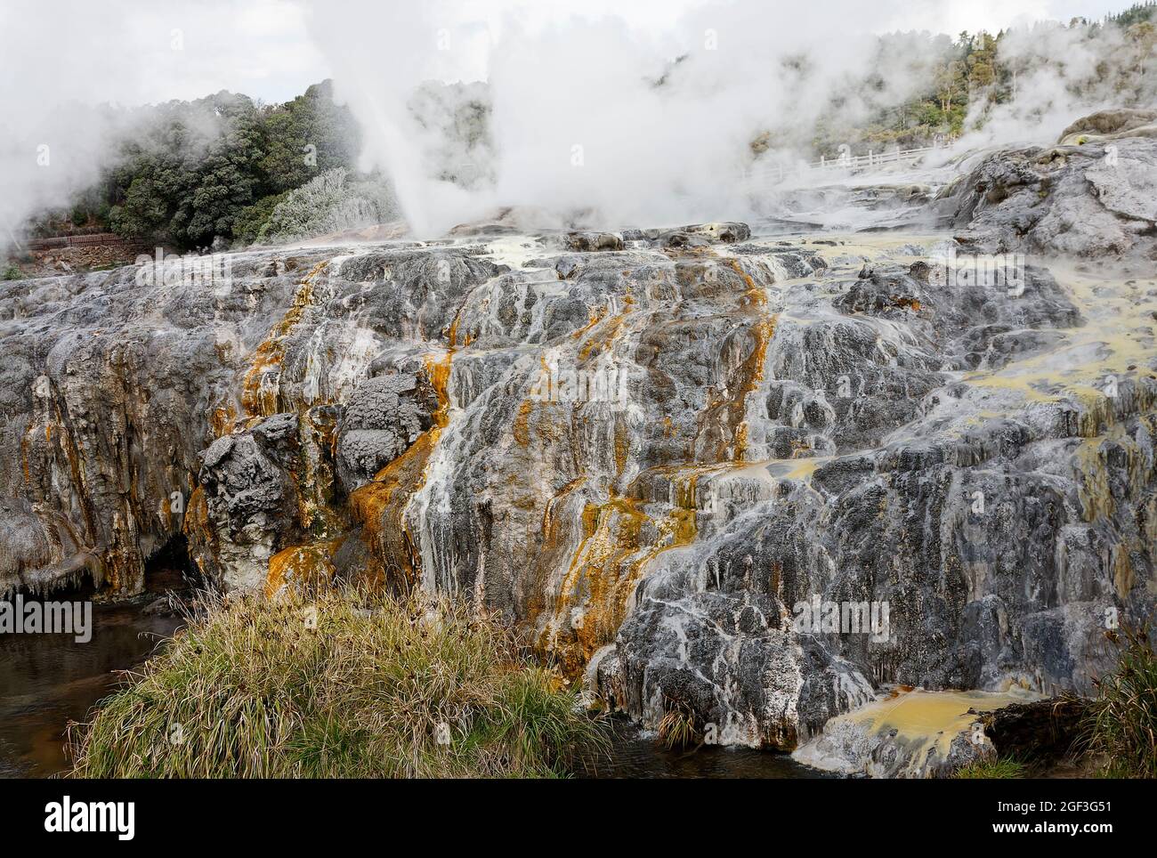 geothermal activity, hot water running over rock hillside, steam clouds ...