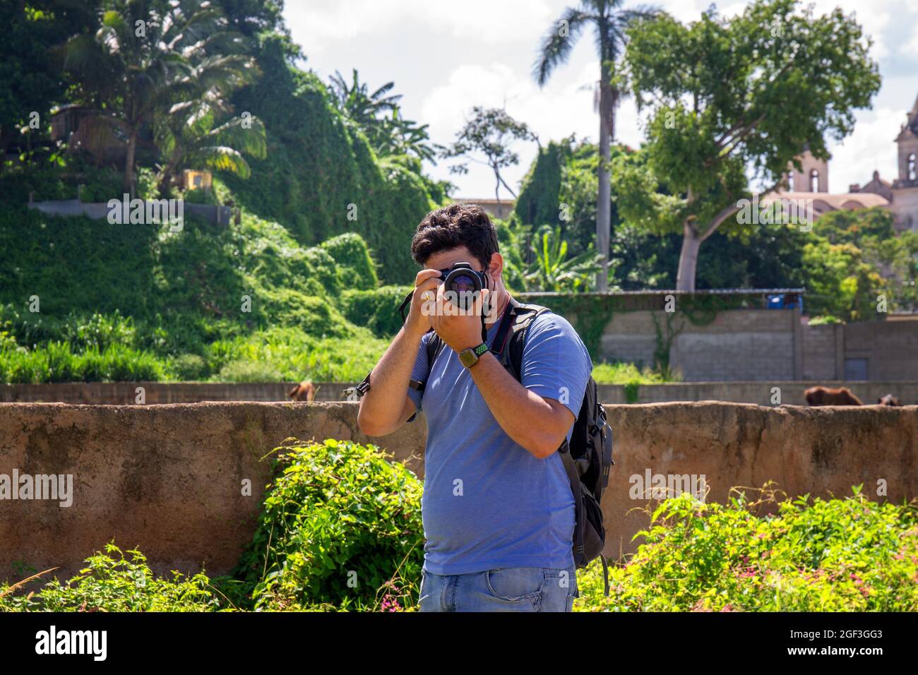Cuban man using his camera to take pictured outdoors during daylight ...