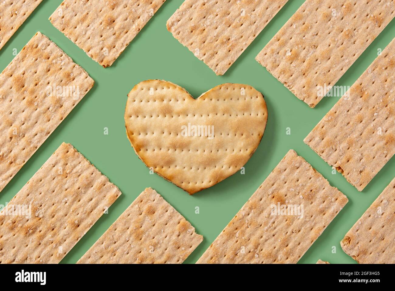 Traditional matzah bread pattern and heart shaped matzah on green ...