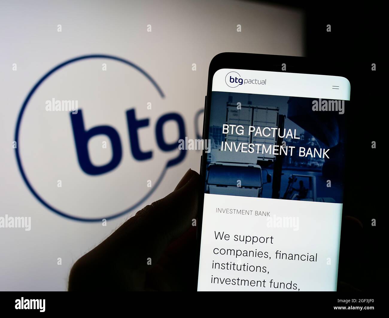 Person holding cellphone with website of Brazilian financial company ...