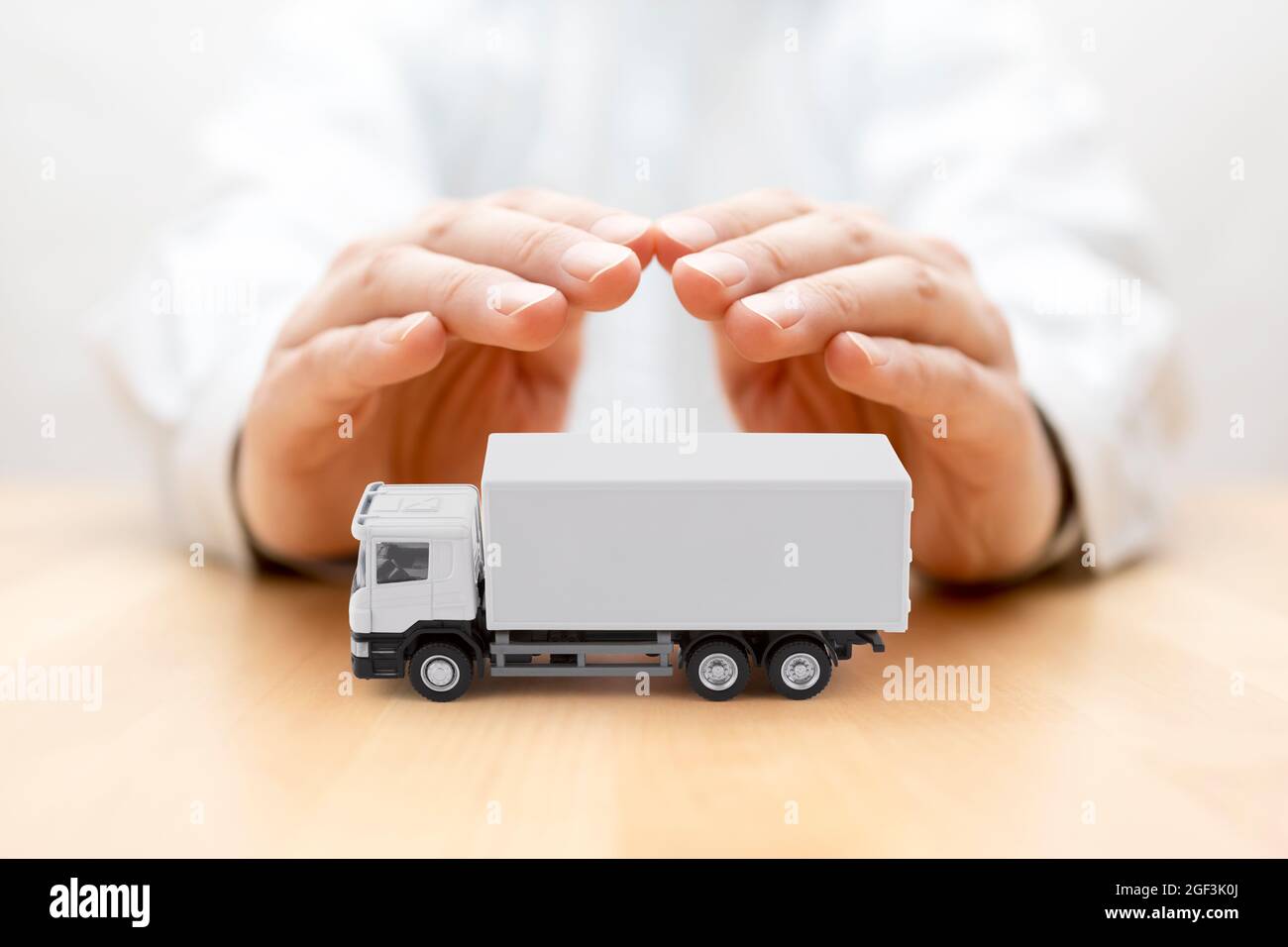 White cargo delivery truck protected by hands Stock Photo - Alamy