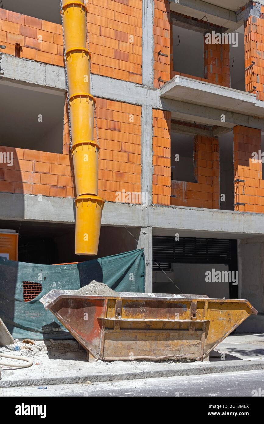 Chute and Skip for Debris at Construction Site Stock Photo - Alamy