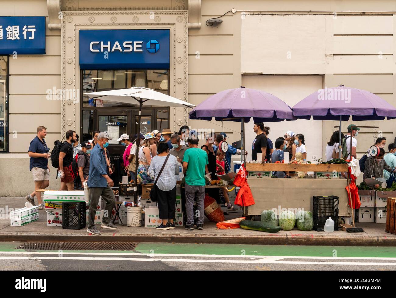 Hordes of people in Chinatown in New York pass street vendors and a ...