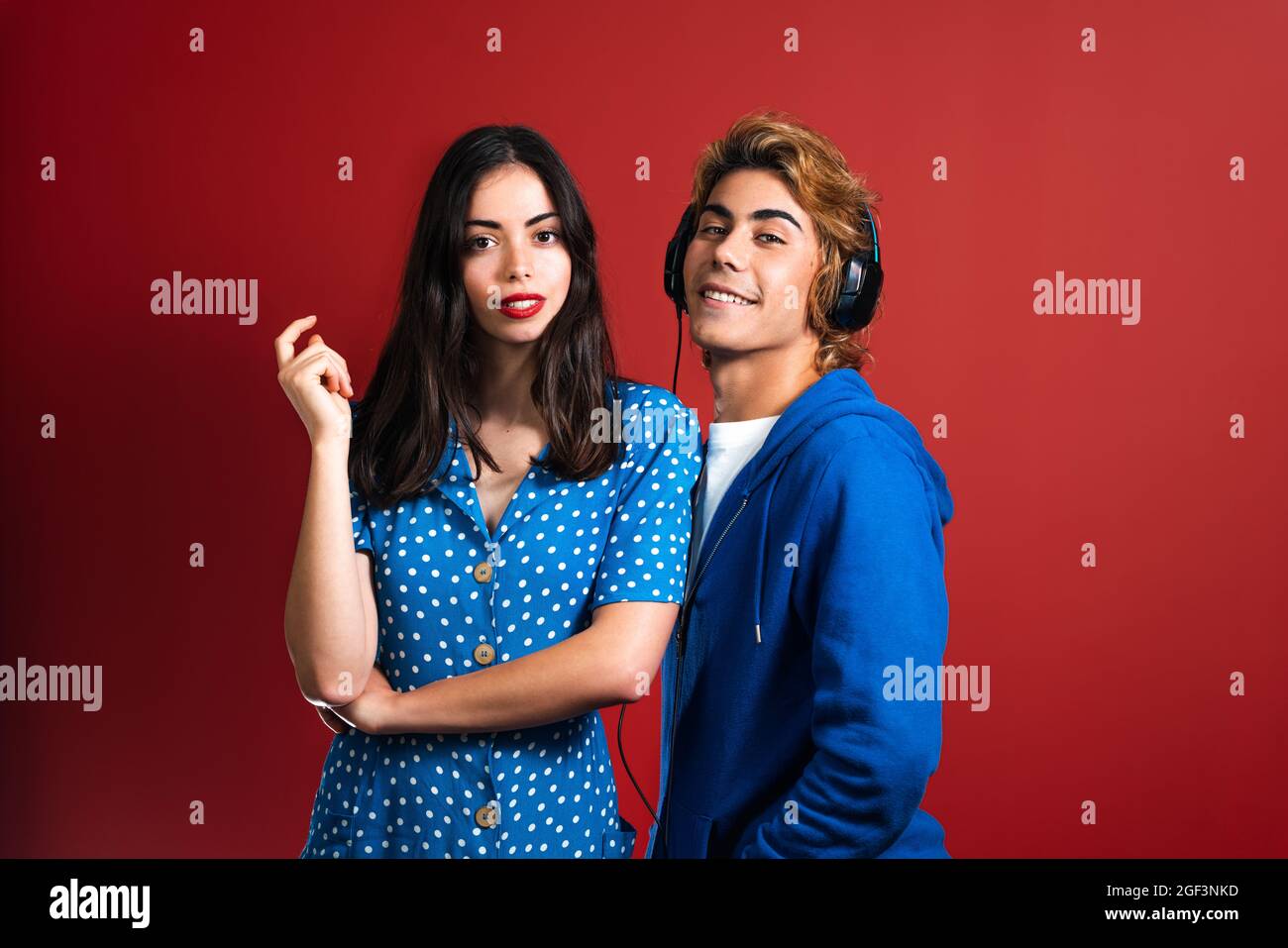 Young stylish couple wearing blue clothes standing on the red ...
