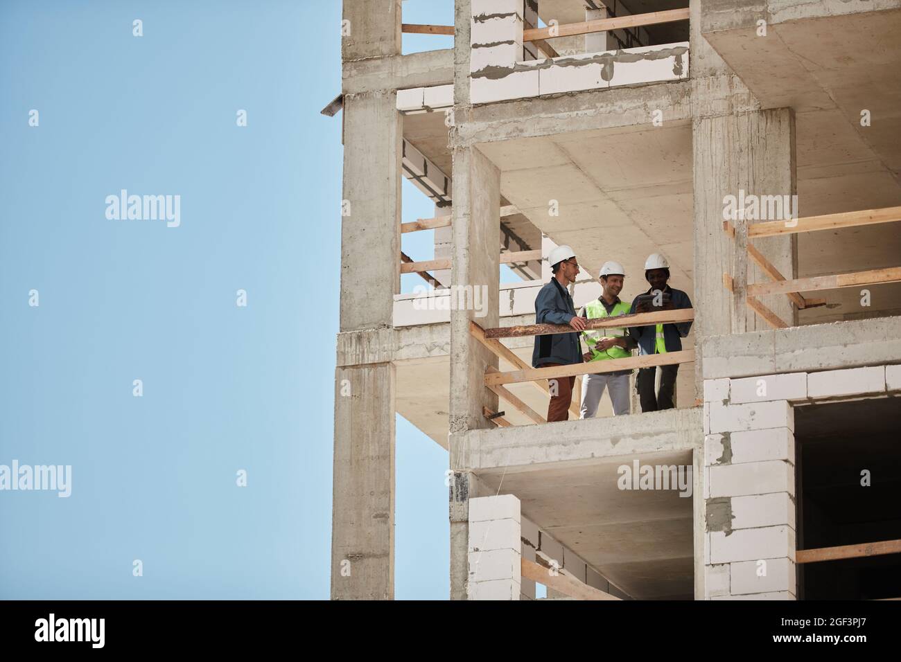 Background image of high rise construction site with group of workers ...