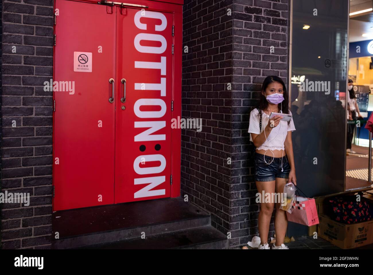 A woman stands outside the Australia's largest clothing retailer Cotton ...