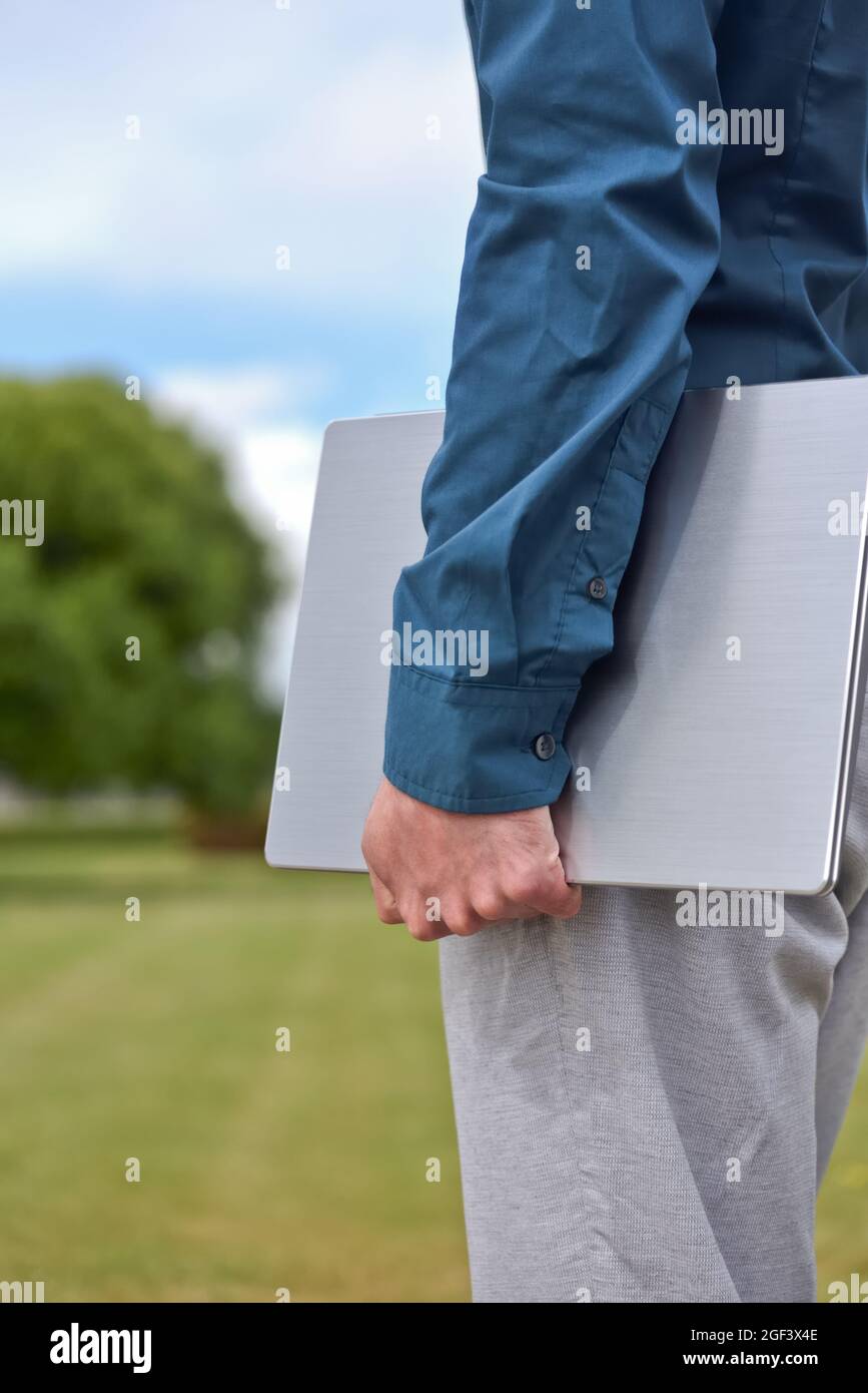 A laptop computer in the hand of a standing man. Computer technology ...