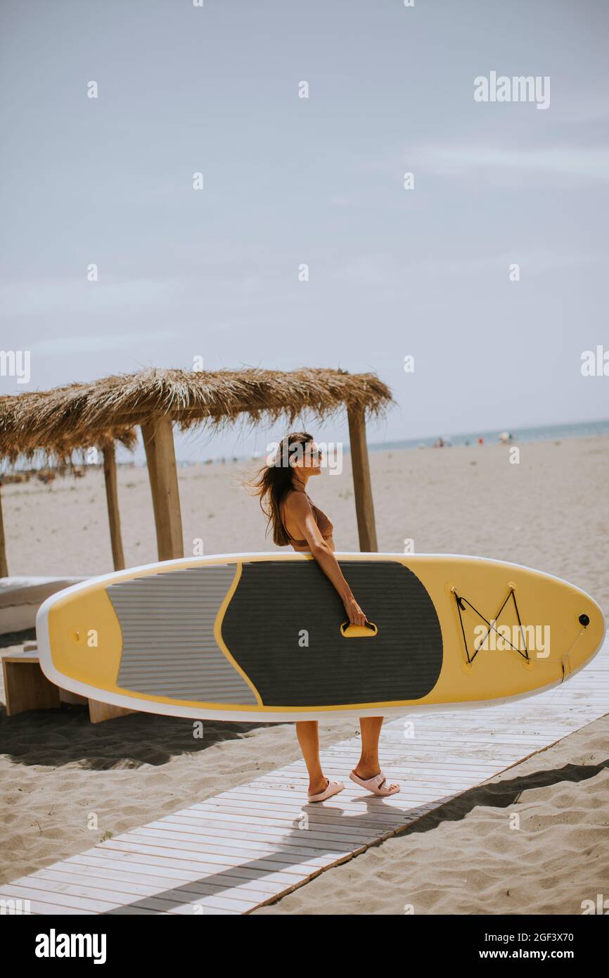 Pretty young women with paddle board on the beach on a summer day Stock ...