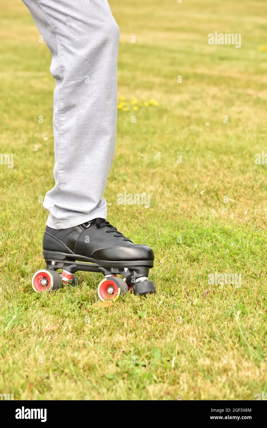 Male leg in roller skates on the background of a grass field. Roller ...