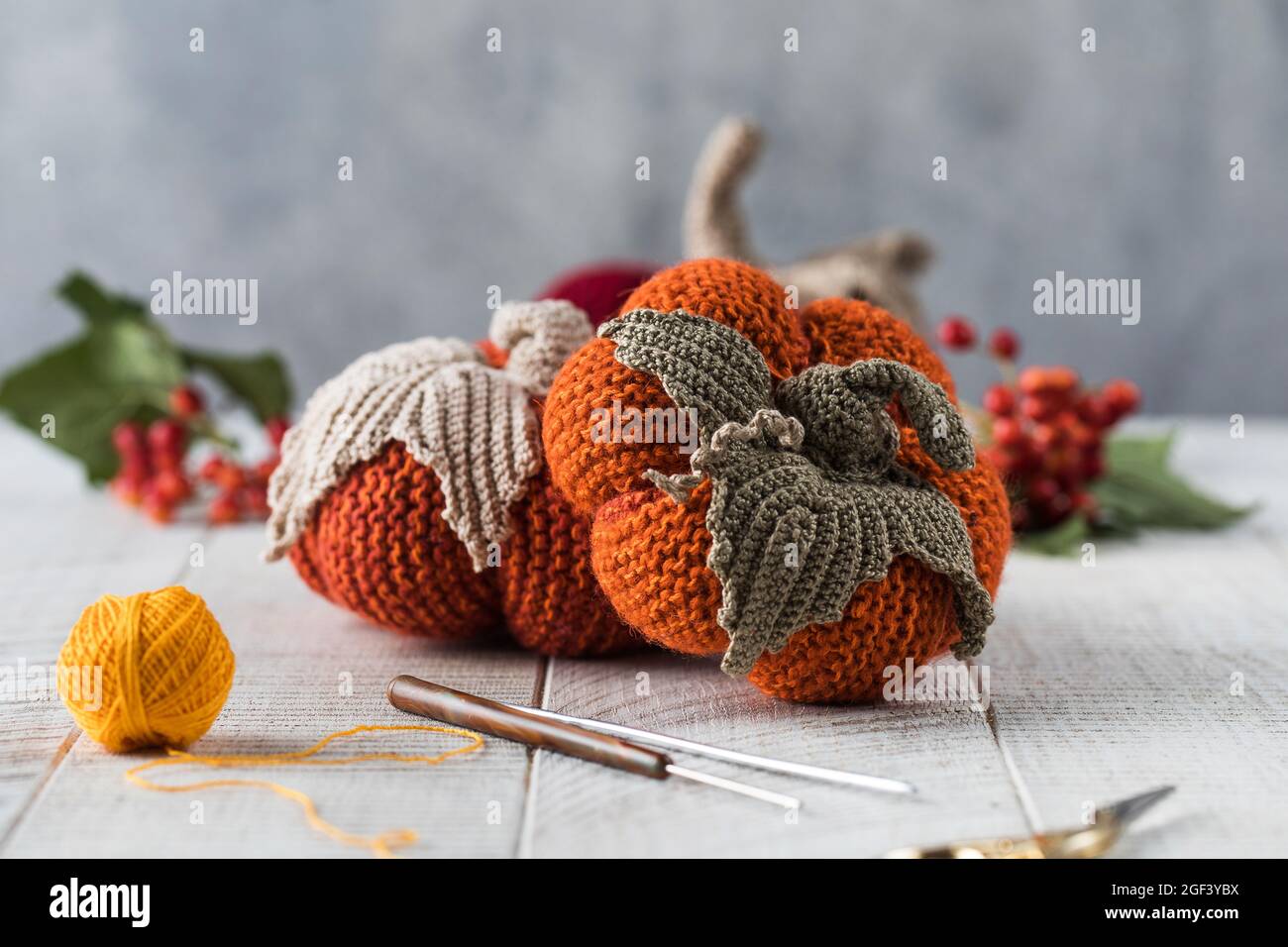 Knitted pumpkins with leaves crochets and scissors on table Stock Photo ...