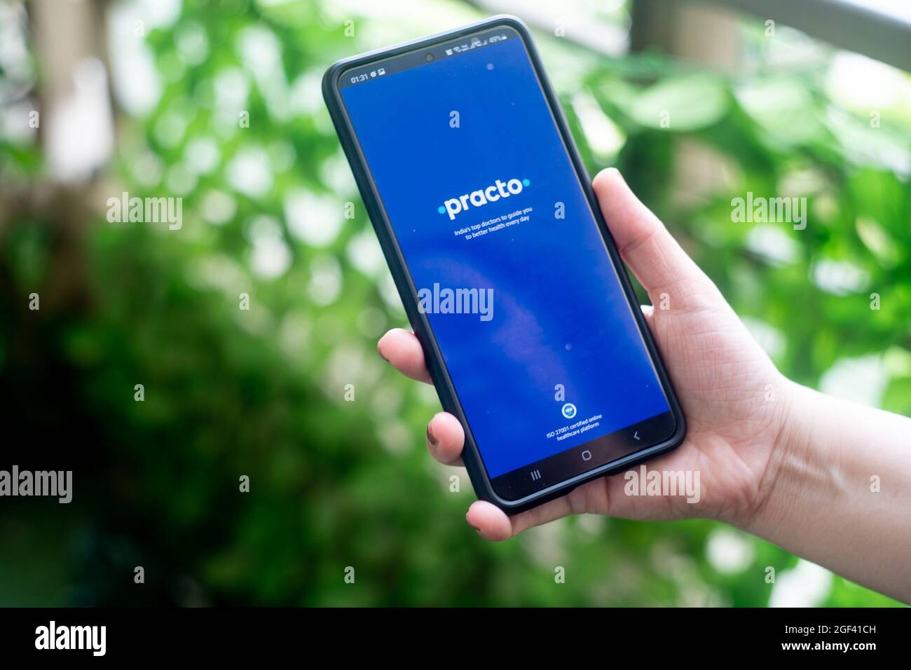 Young indian woman holding mobile phone with practo app with doctors ...