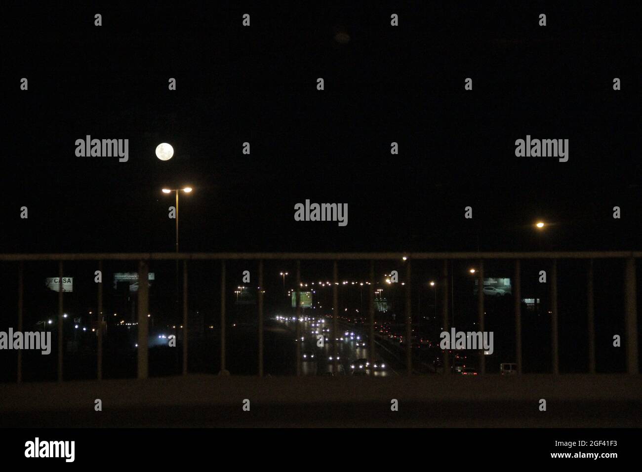 Beautiful night cityscape of the moon and street traffic from a bridge ...