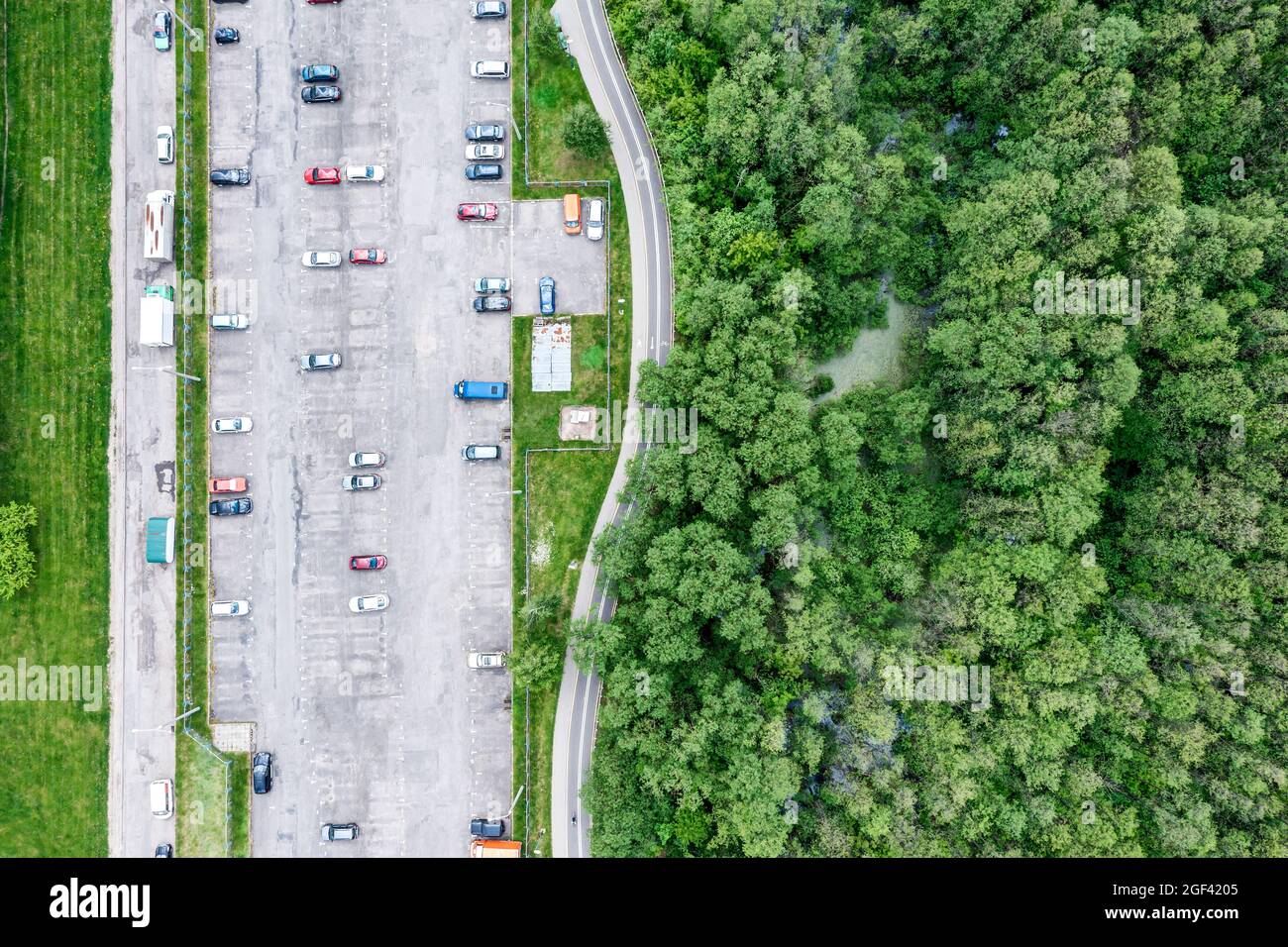 aerial top view of parking lot with parked cars and winding bike lane ...