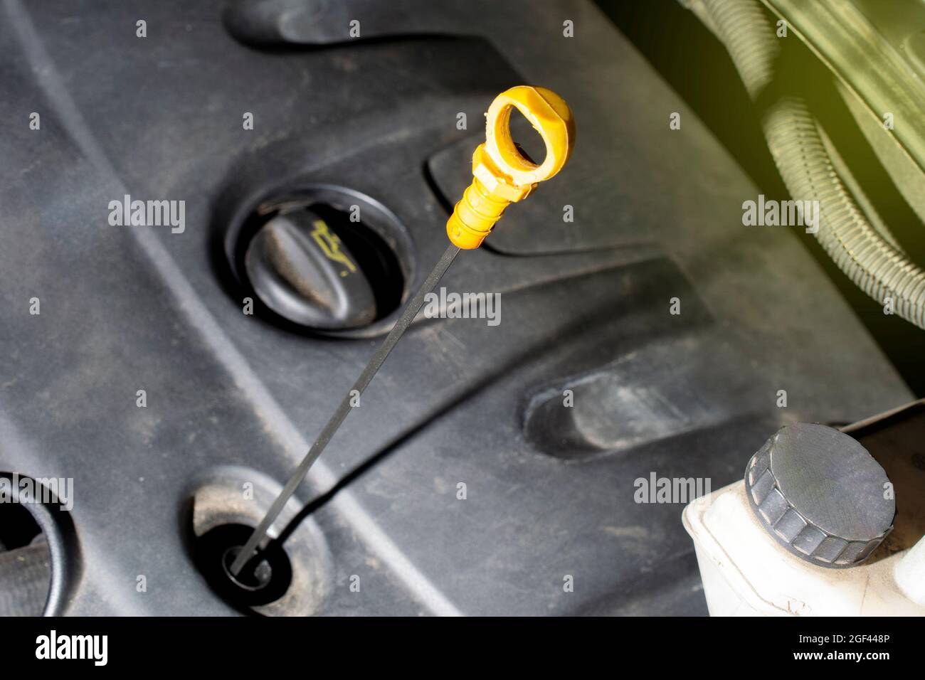 Yellow oil dipstick in car engine bay. Minimal car service, maintenance ...