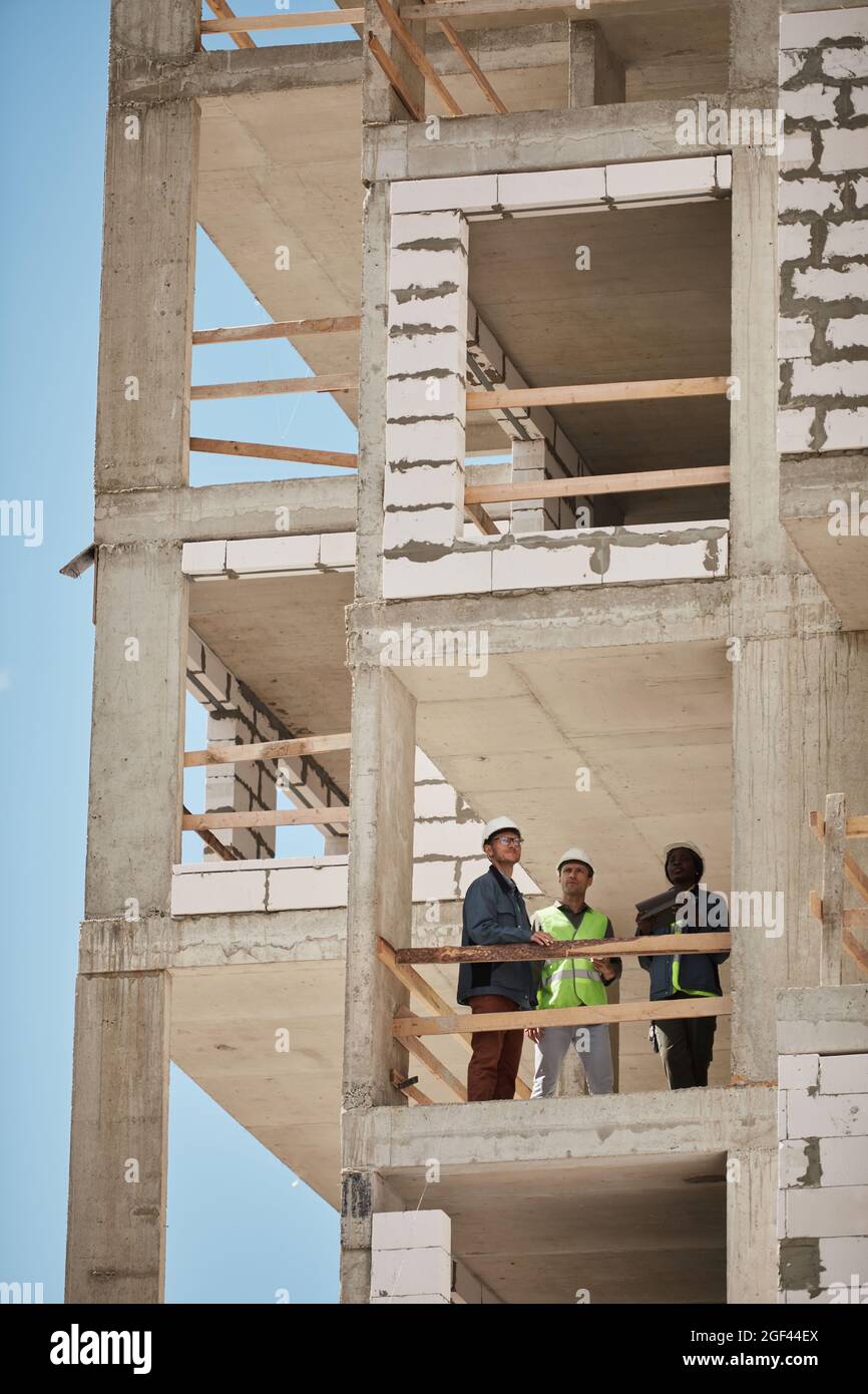 Vertical background image of high rise construction site with group of ...