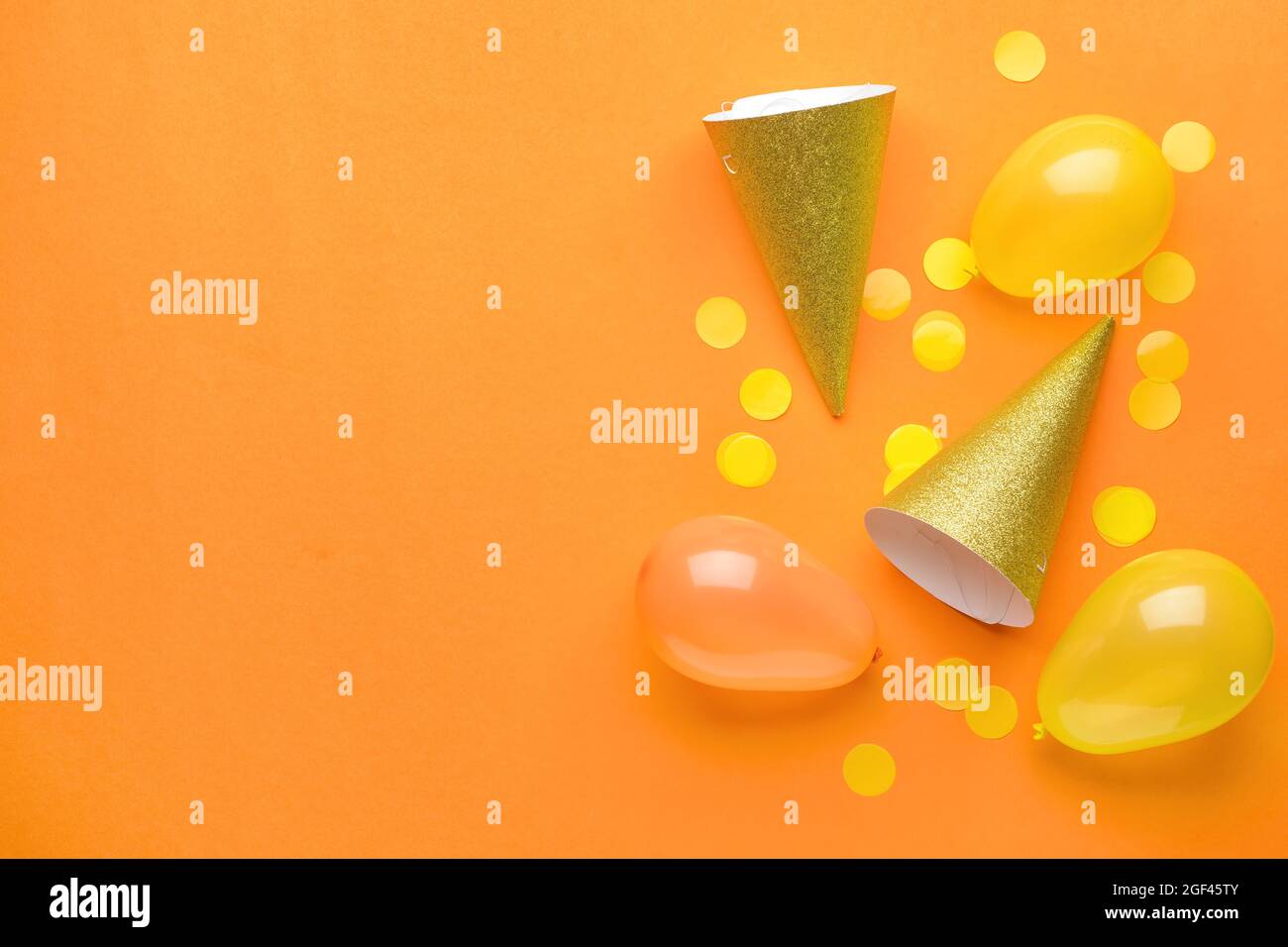 Party hats, balloons and confetti on color background Stock Photo - Alamy