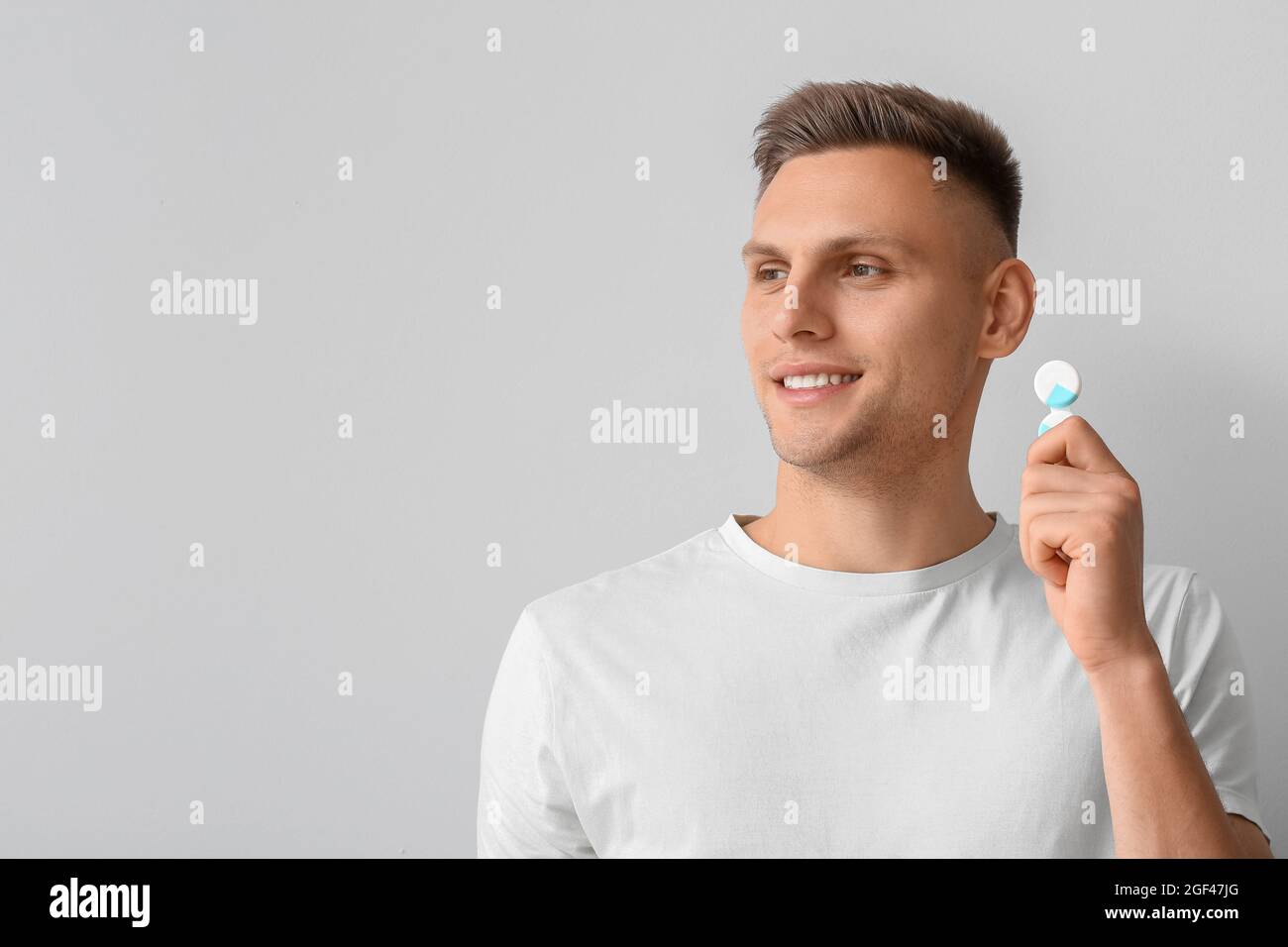 Young man with contact lenses on light background Stock Photo - Alamy