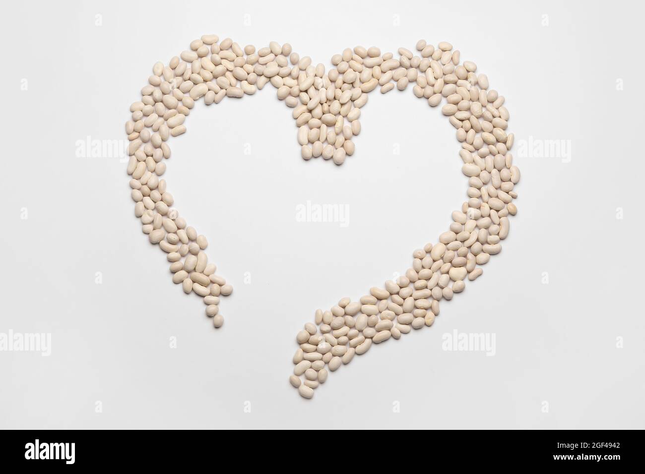 Heart made of raw beans on white background Stock Photo - Alamy