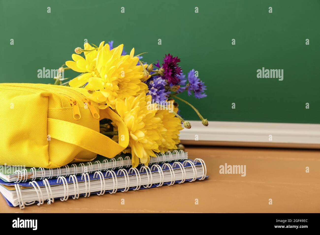 Beautiful flowers and stationery on table in classroom. Teacher's Day ...