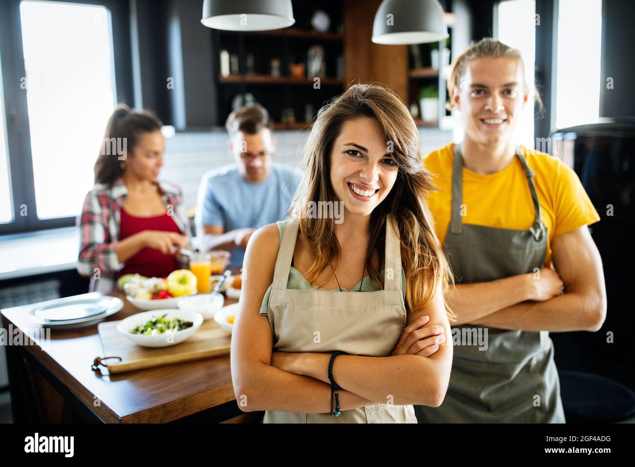 Group of happy friends having fun in kitchen, cooking food together ...