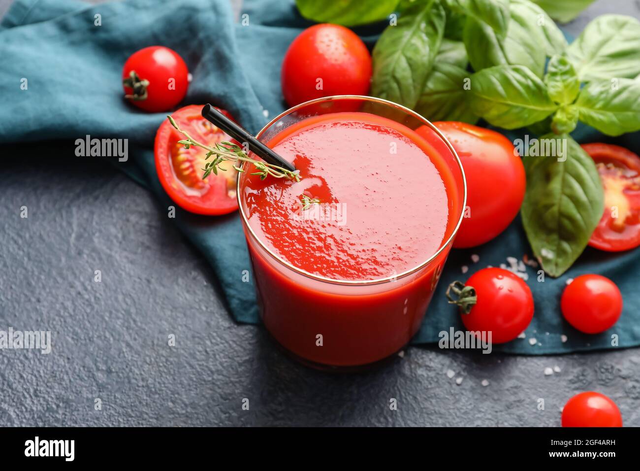 Glass of tasty tomato juice on dark background Stock Photo - Alamy